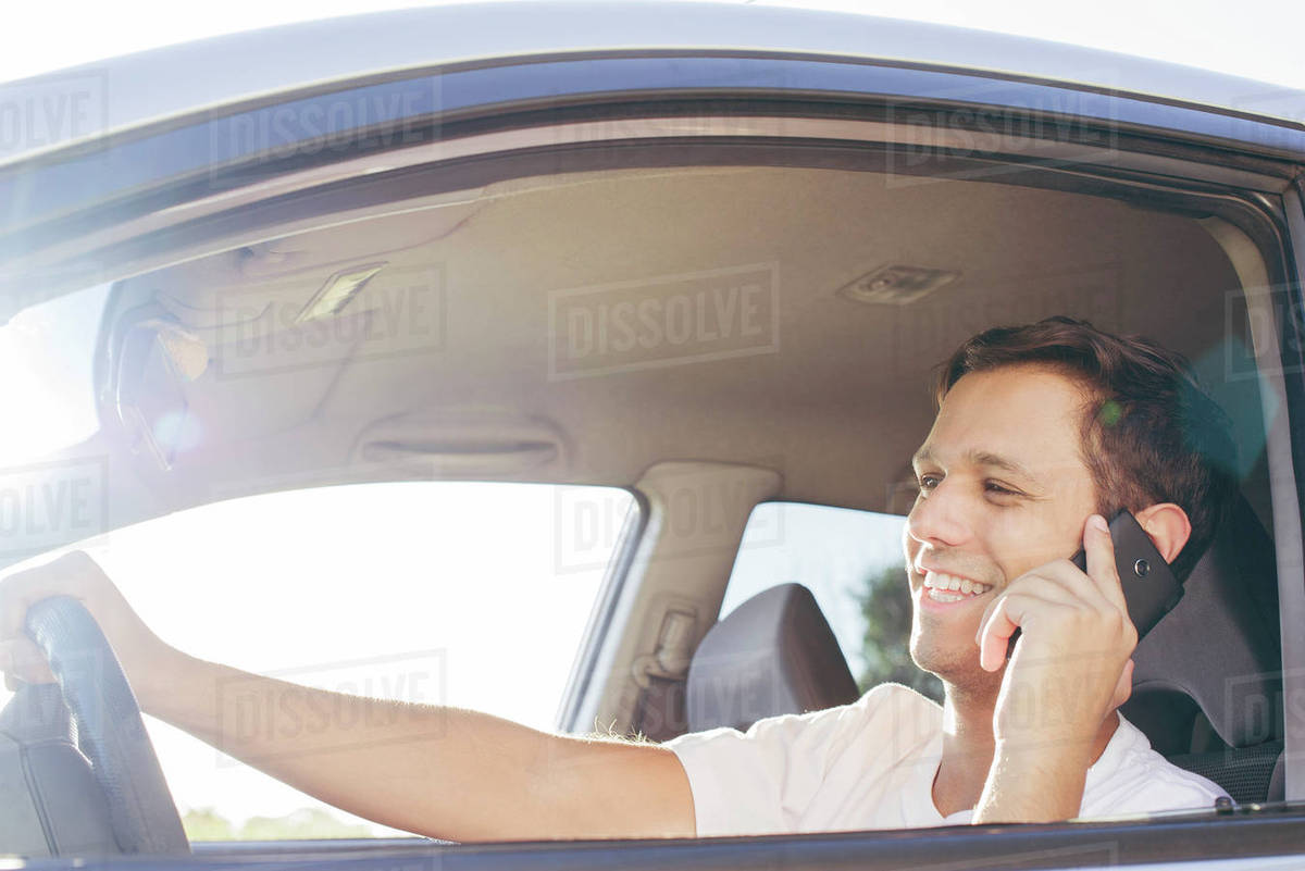 Man chatting on phone while driving - Stock Photo - Dissolve