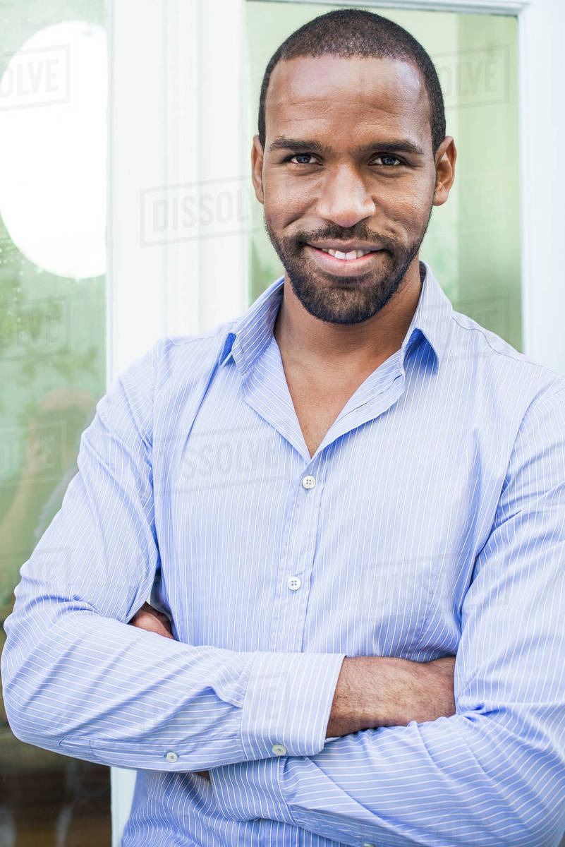 Man smiling with arms folded across chest, portrait - Royalty-free ...