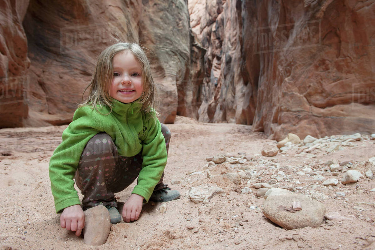 Girl looking at rocks, portrait - Royalty-free Stock Photo | Dissolve