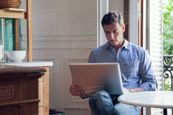 Man using laptop computer at home - Royalty-free Stock Photo | Dissolve