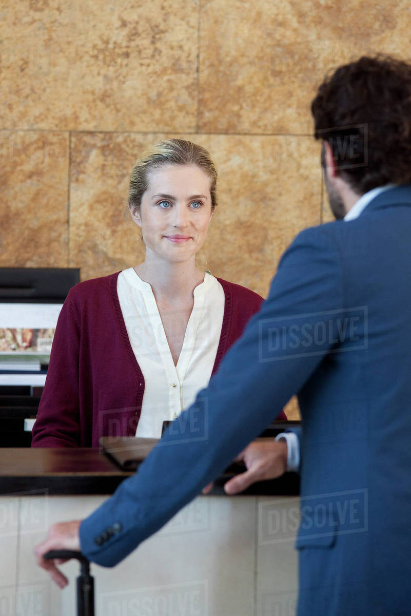 Hotel receptionist assisting guest - Royalty-free Stock Photo | Dissolve