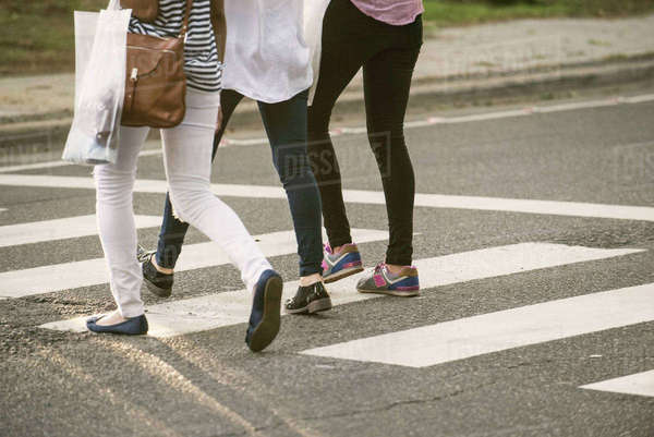Women walking in crosswalk, low section - Stock Photo - Dissolve