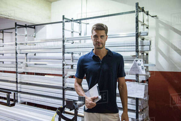 Man in factory warehouse, portrait - Stock Photo - Dissolve