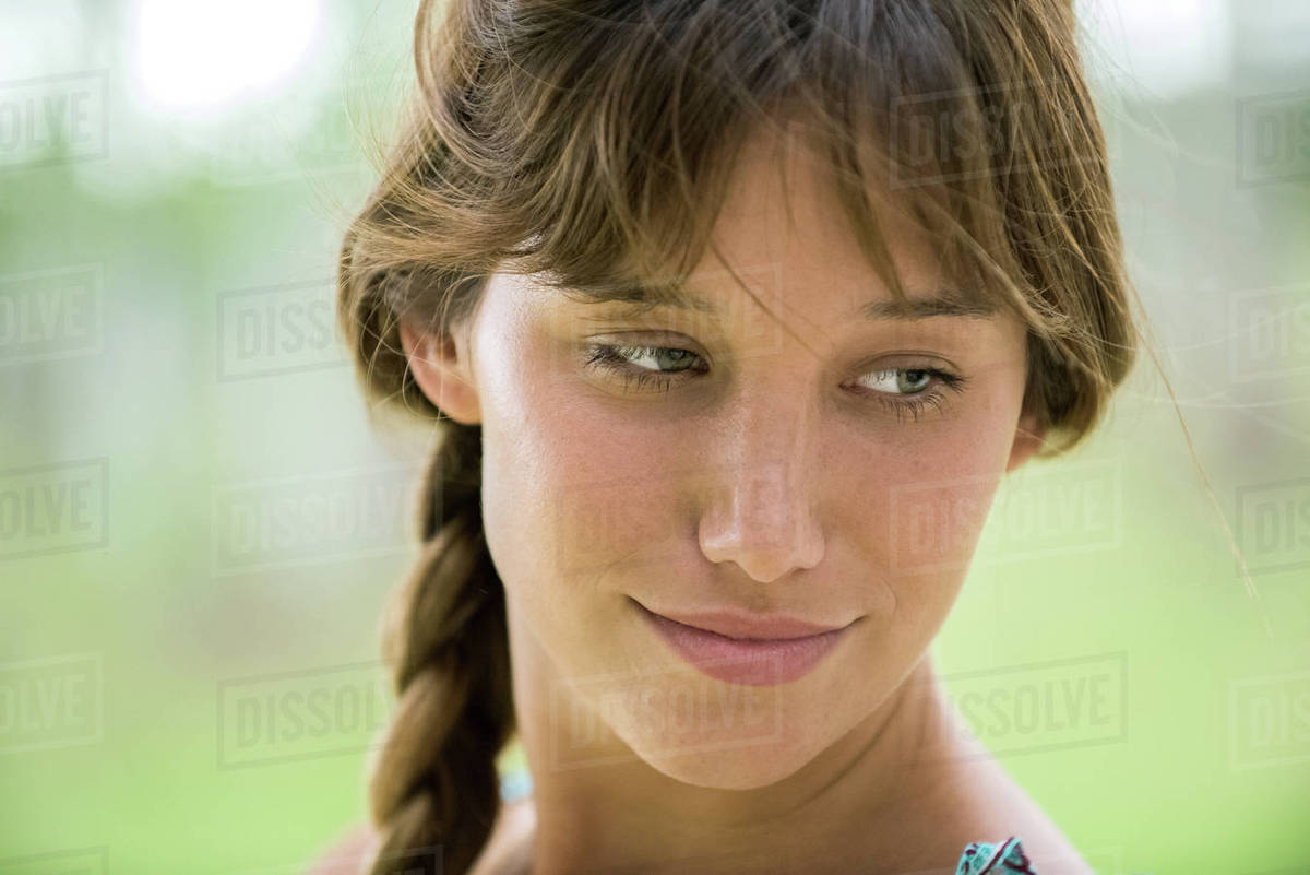 Young woman looking down in thought, portrait - Stock Photo - Dissolve