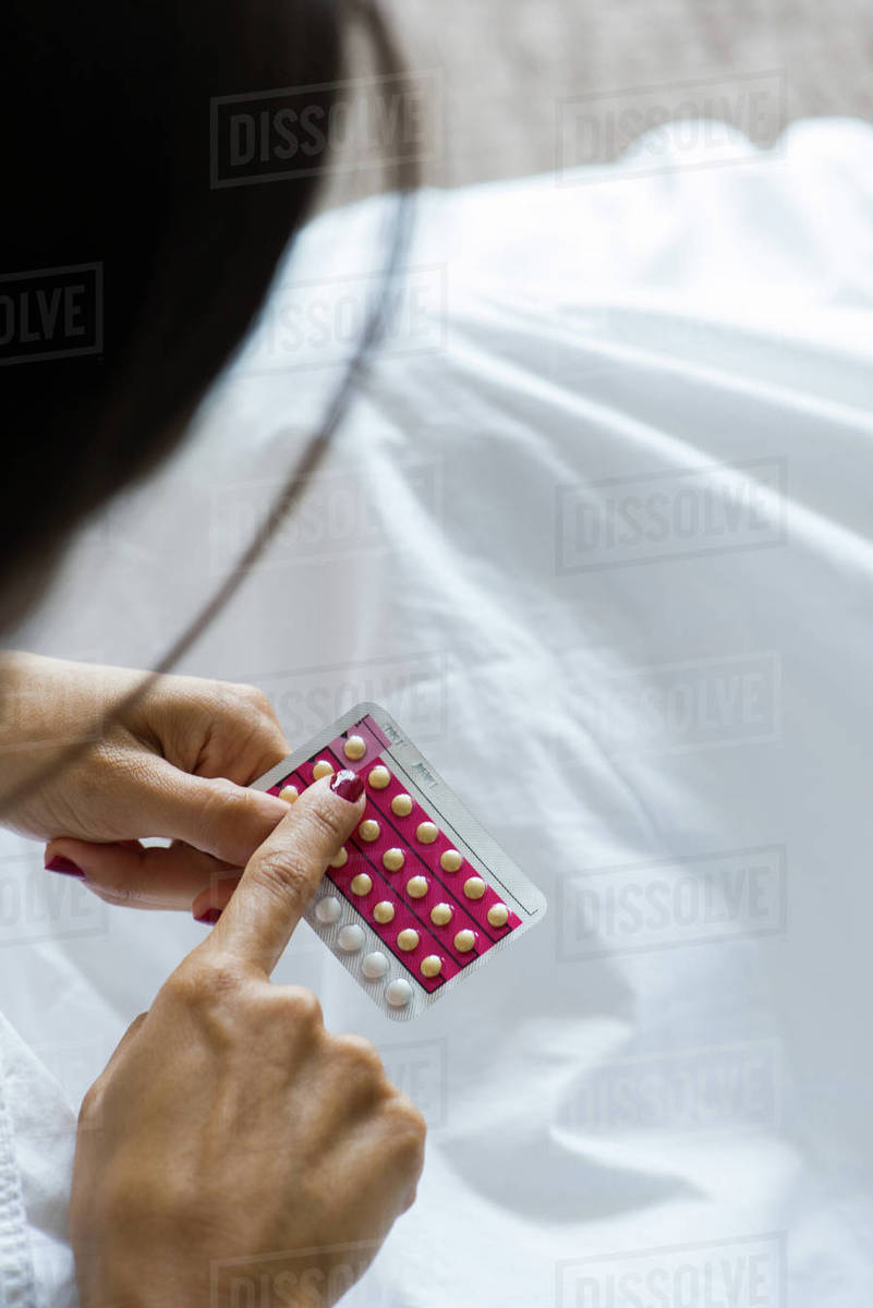 Woman holding birth control pills - Royalty-free Stock Photo | Dissolve