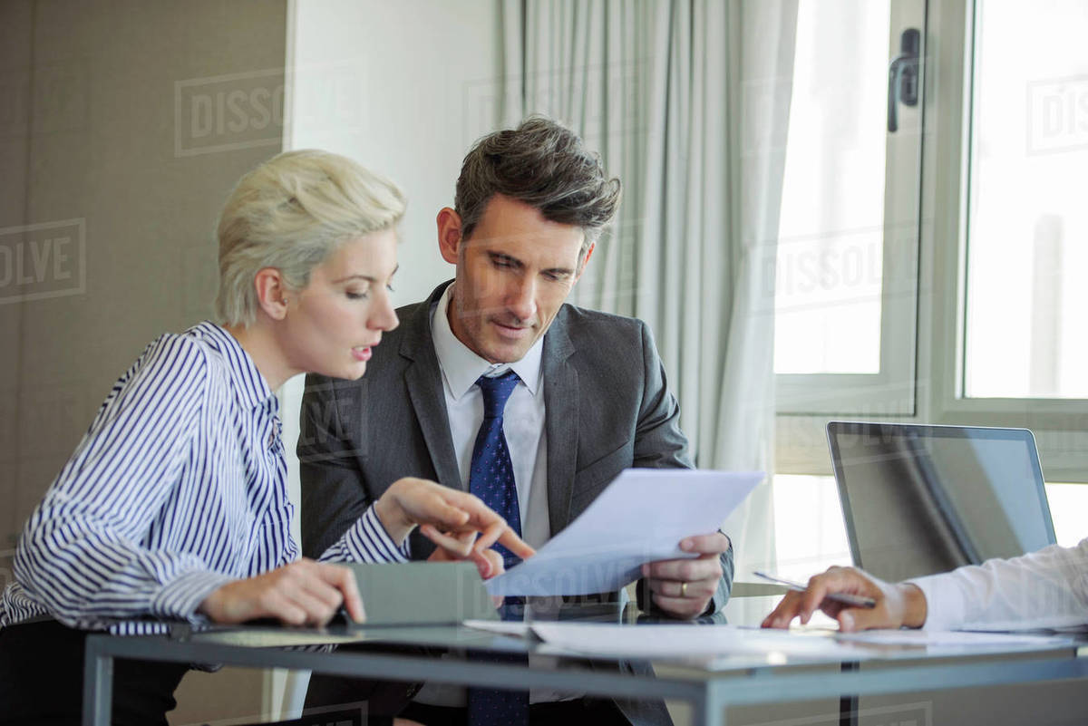 Man and woman reviewing document - Stock Photo - Dissolve