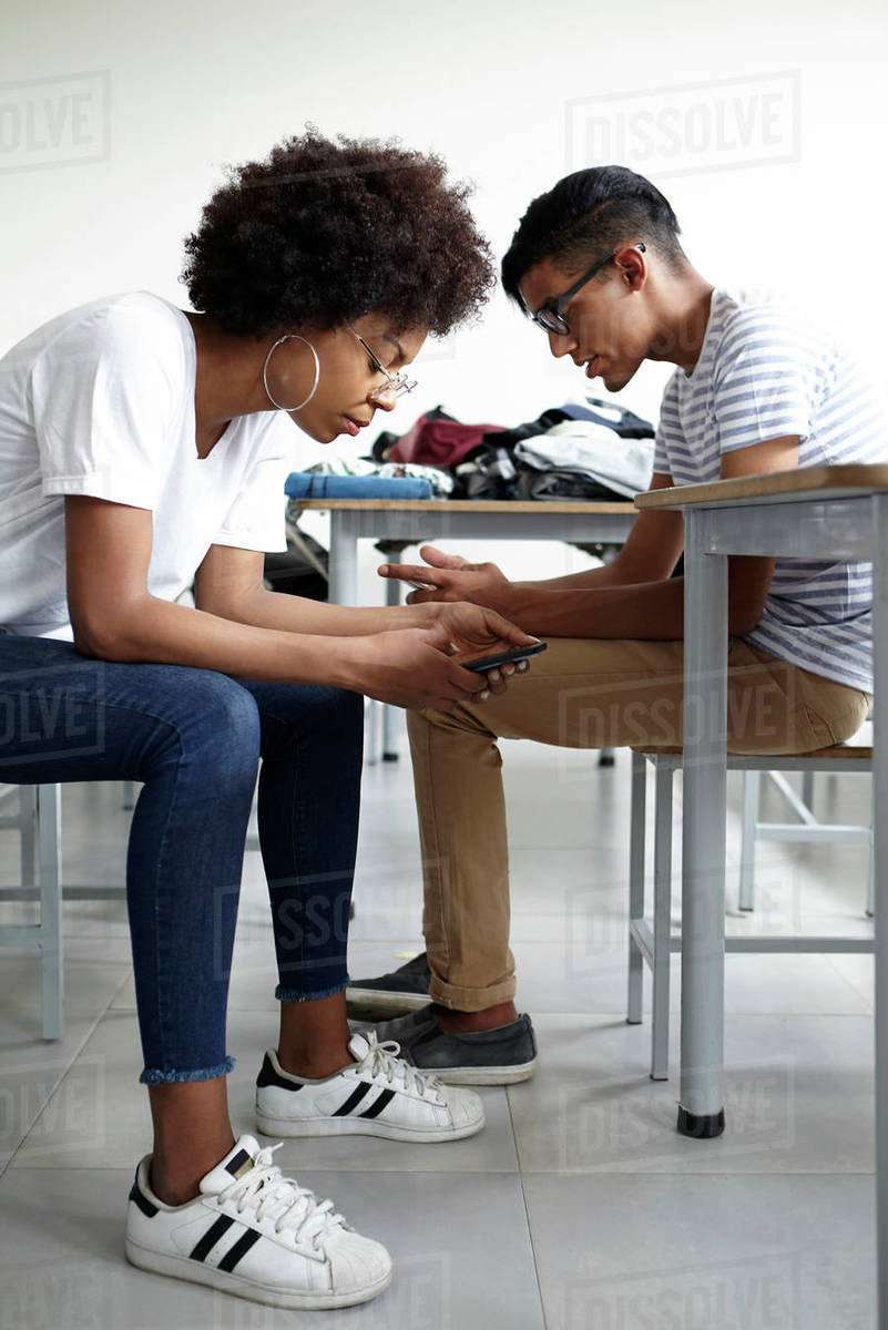 Students in classroom using smart phones - Stock Photo - Dissolve