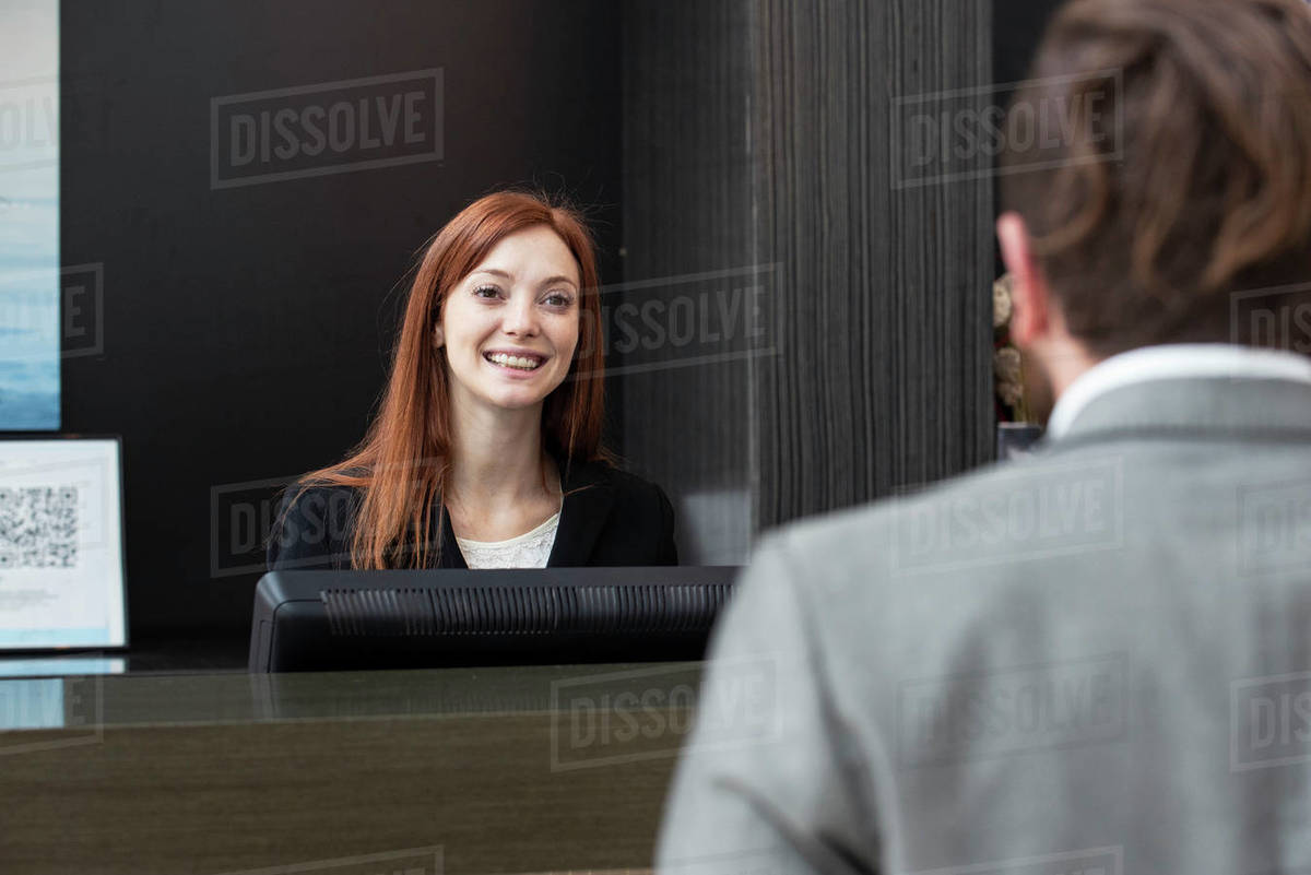 Female receptionist looking at businessman - Royalty-free Stock Photo ...