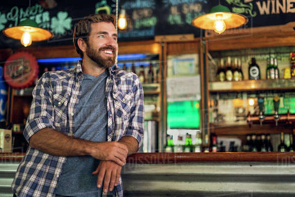 Man leaning against bar counter - Royalty-free Stock Photo | Dissolve