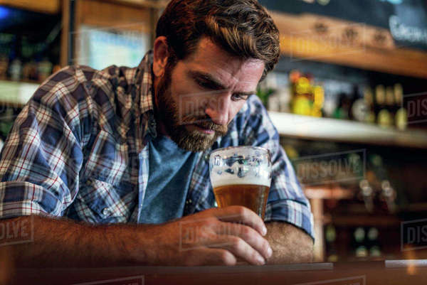 Sad man sitting in beer bar - Royalty-free Stock Photo | Dissolve