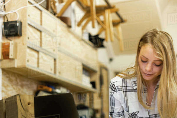 Woman writing on notepad in workshop - Stock Photo - Dissolve