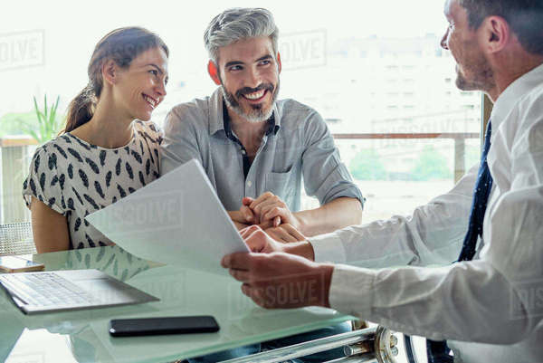 Real estate agent discussing document with couple - Royalty-free Stock ...