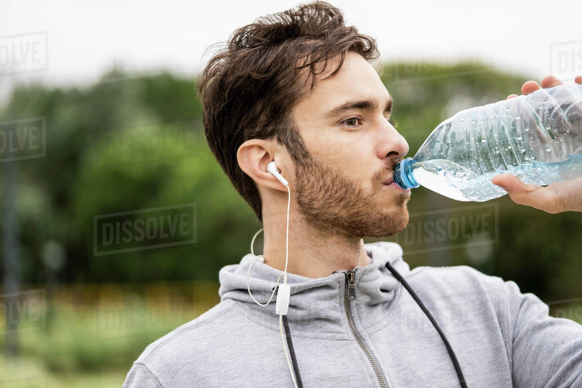 Young man drinking water - Royalty-free Stock Photo | Dissolve