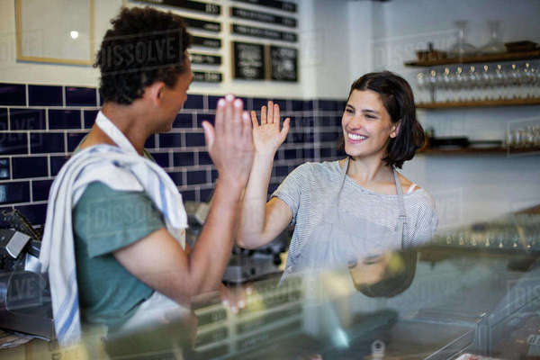 Grocery store female worker high fiving with male colleague - Royalty ...