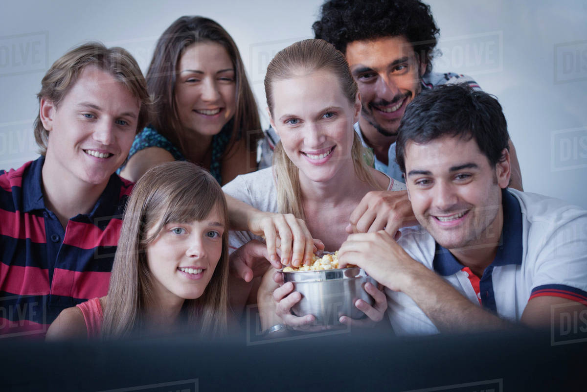 Friends sharing popcorn and watching movie together - Stock Photo ...