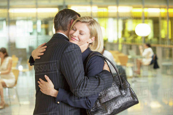Business people hugging in office - Royalty-free Stock Photo | Dissolve
