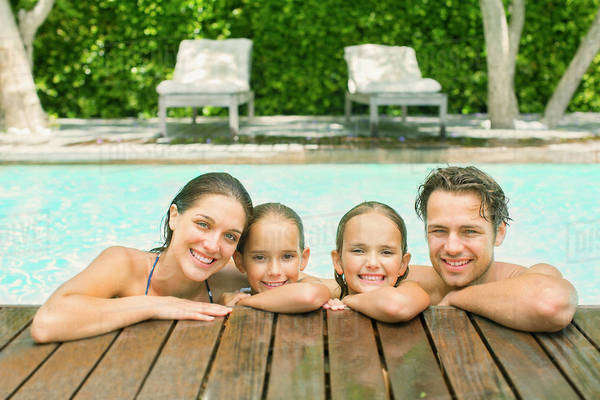 Family relaxing together in pool - Royalty-free Stock Photo | Dissolve