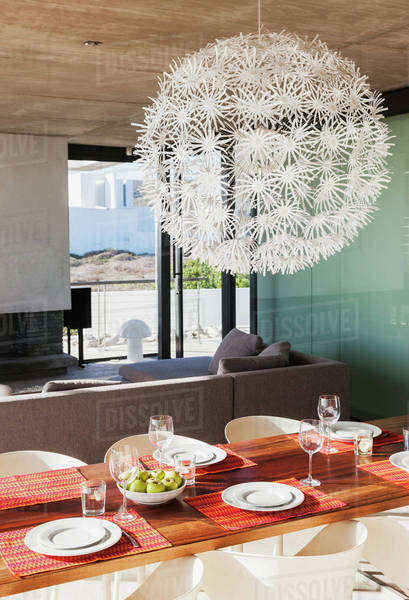 Chandelier over set dining table in modern dining room - Royalty-free ...