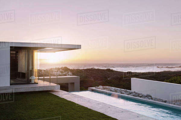 Modern house overlooking ocean at sunset - Stock Photo - Dissolve