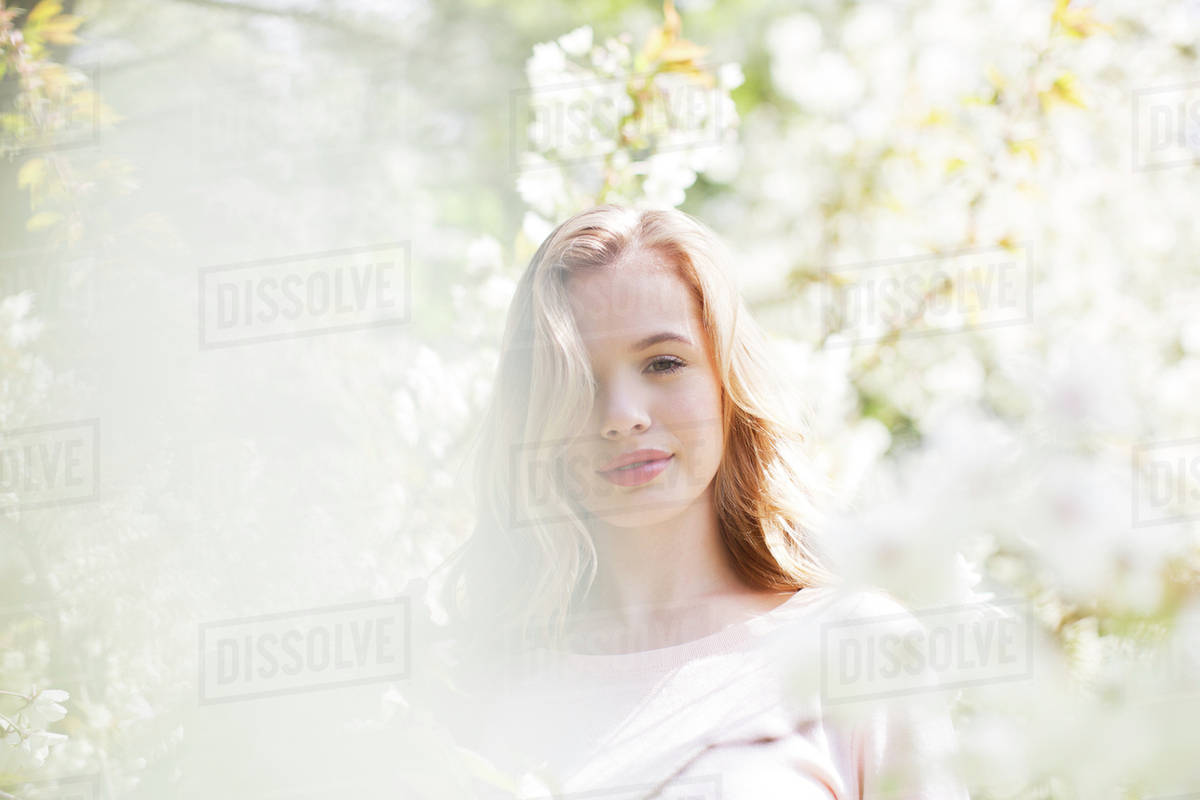 Woman under tree with white blossoms - Stock Photo - Dissolve
