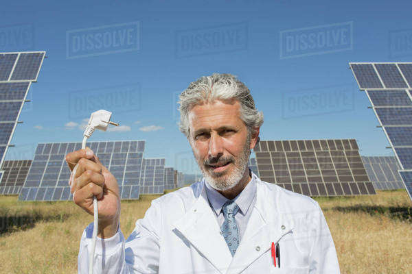 Scientist holding plug to solar panels - Royalty-free Stock Photo ...