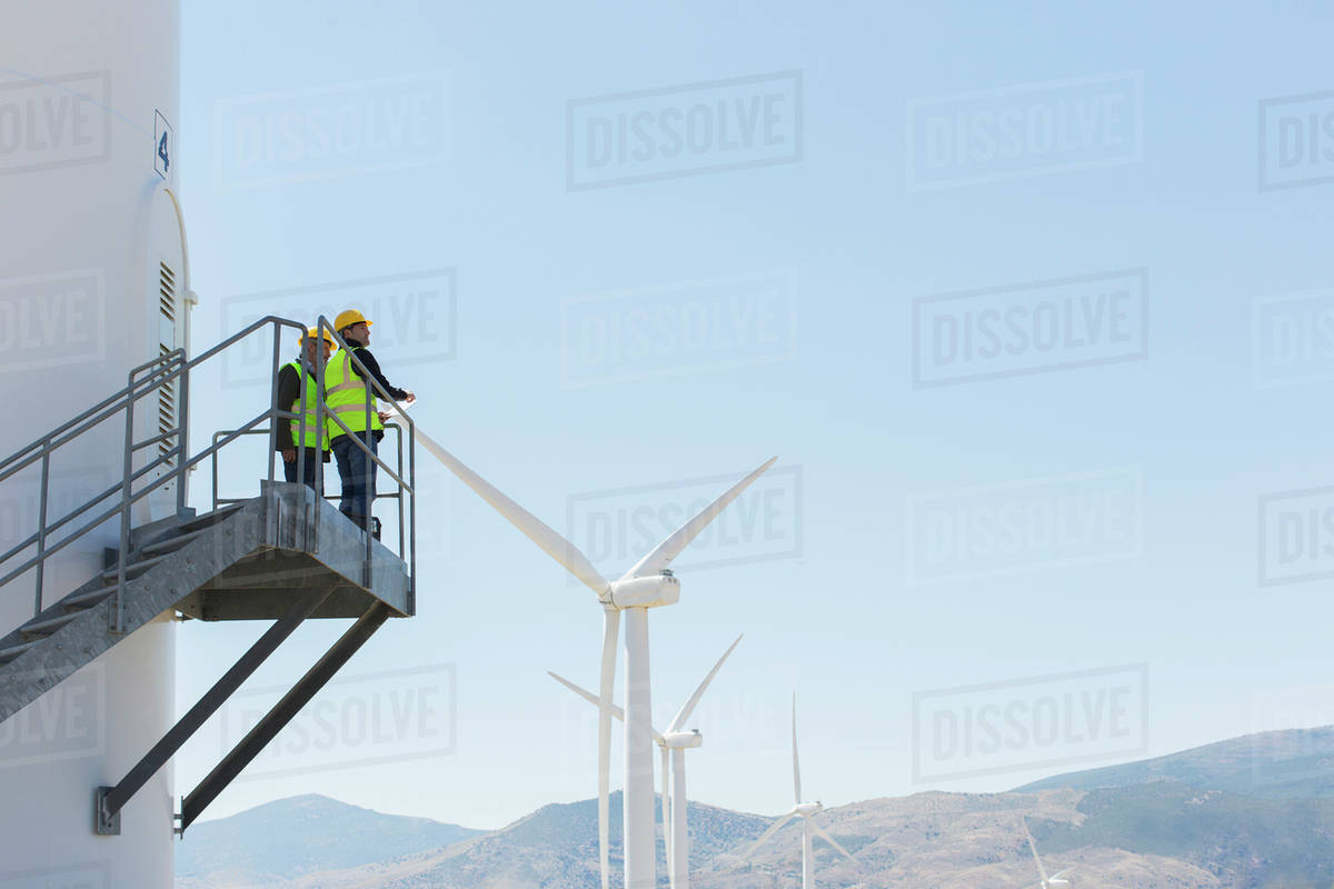 Workers standing on wind turbine in rural landscape - Stock Photo ...