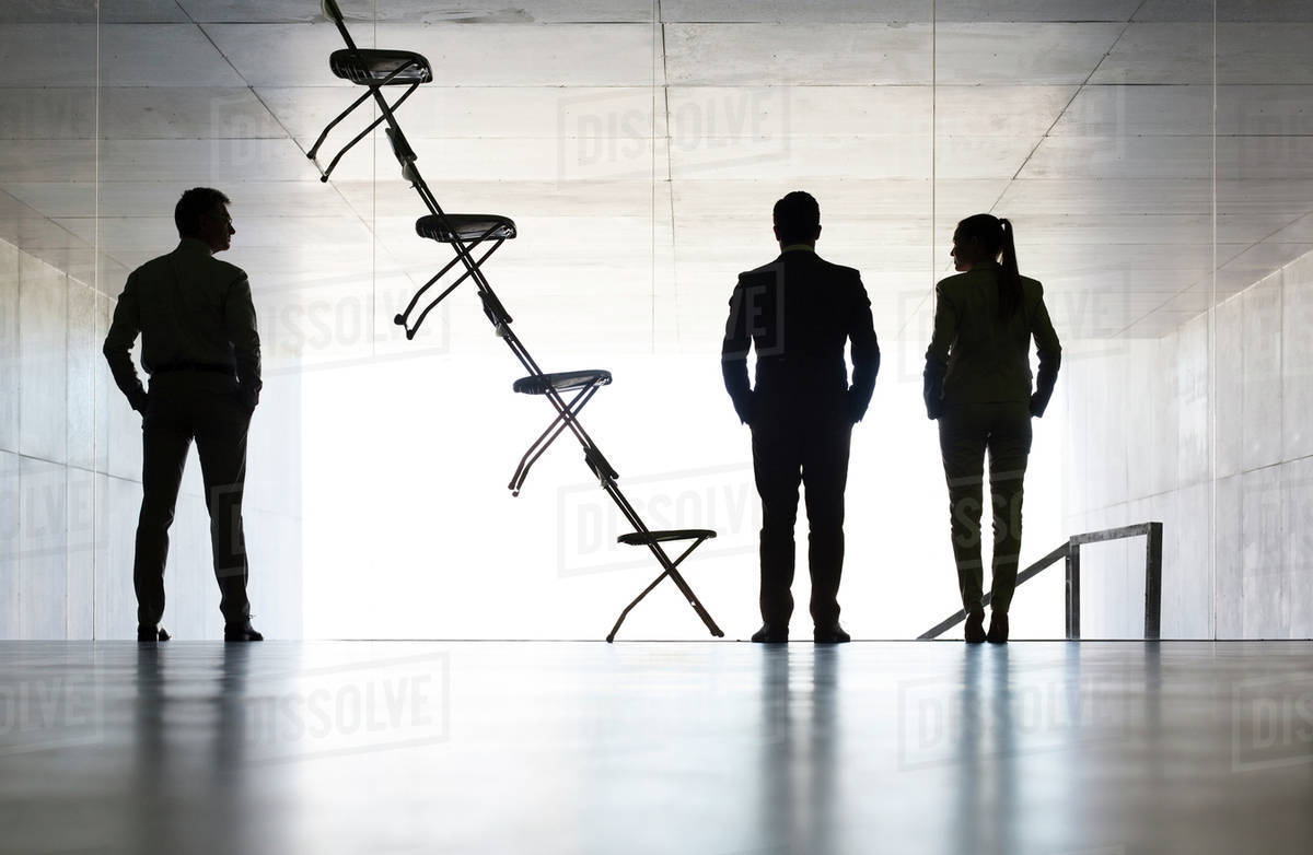 Business people standing next to office chair installation art - Stock ...