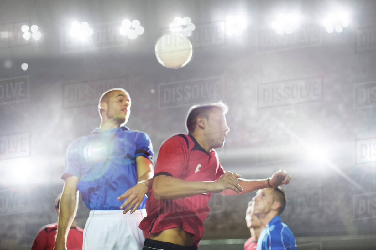 Soccer players jumping for ball on field - Royalty-free Stock Photo ...