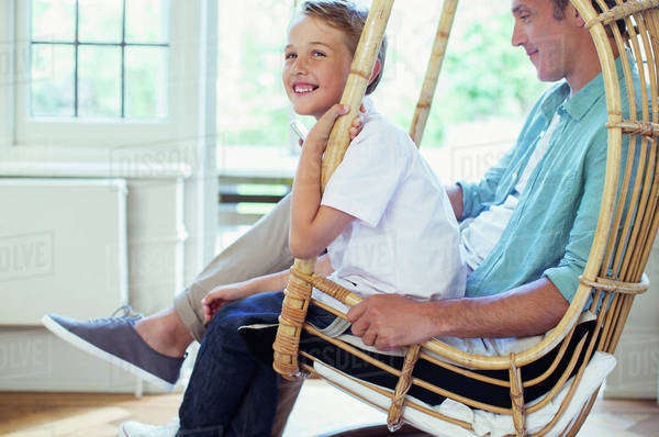Father and son sitting in wicker chair - Royalty-free Stock Photo ...