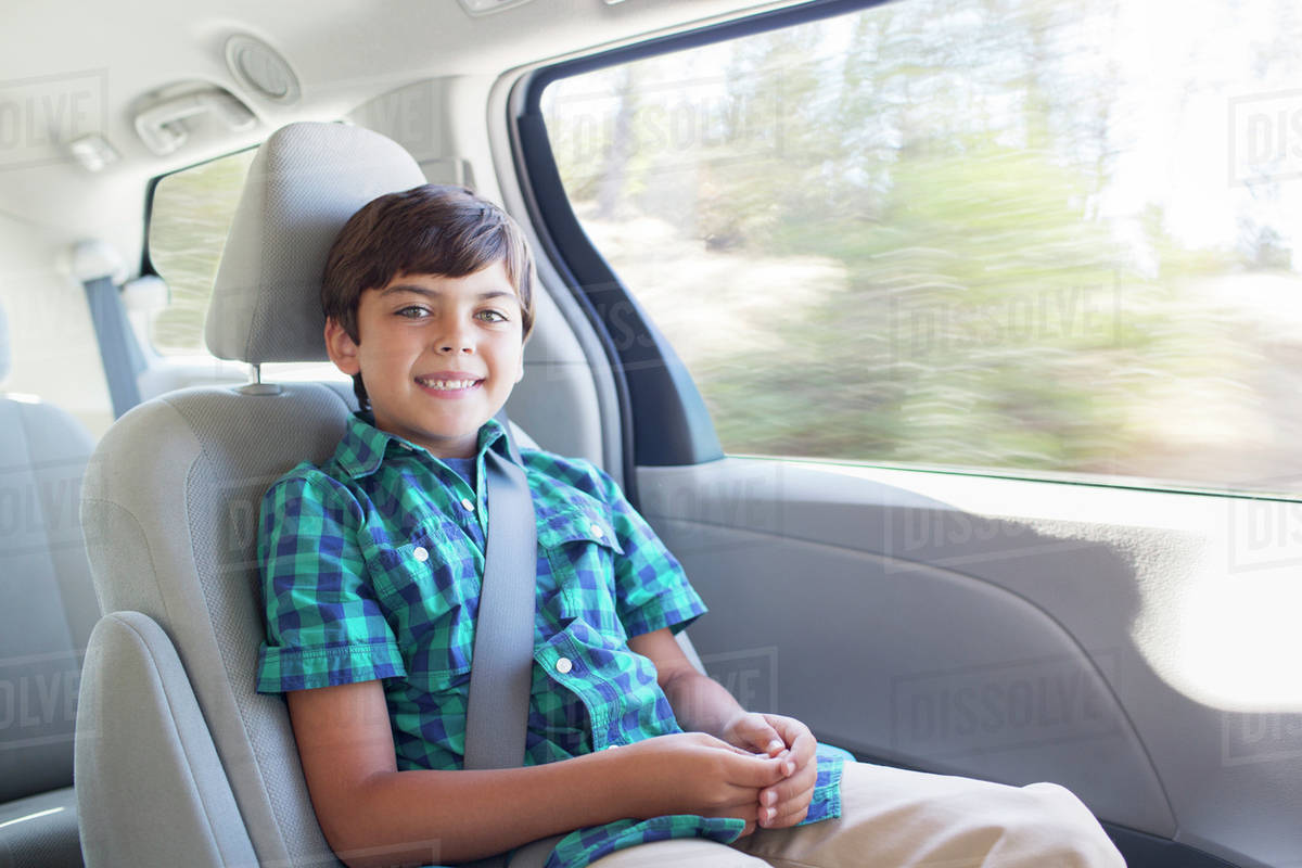 Portrait of smiling boy inside car - Stock Photo - Dissolve