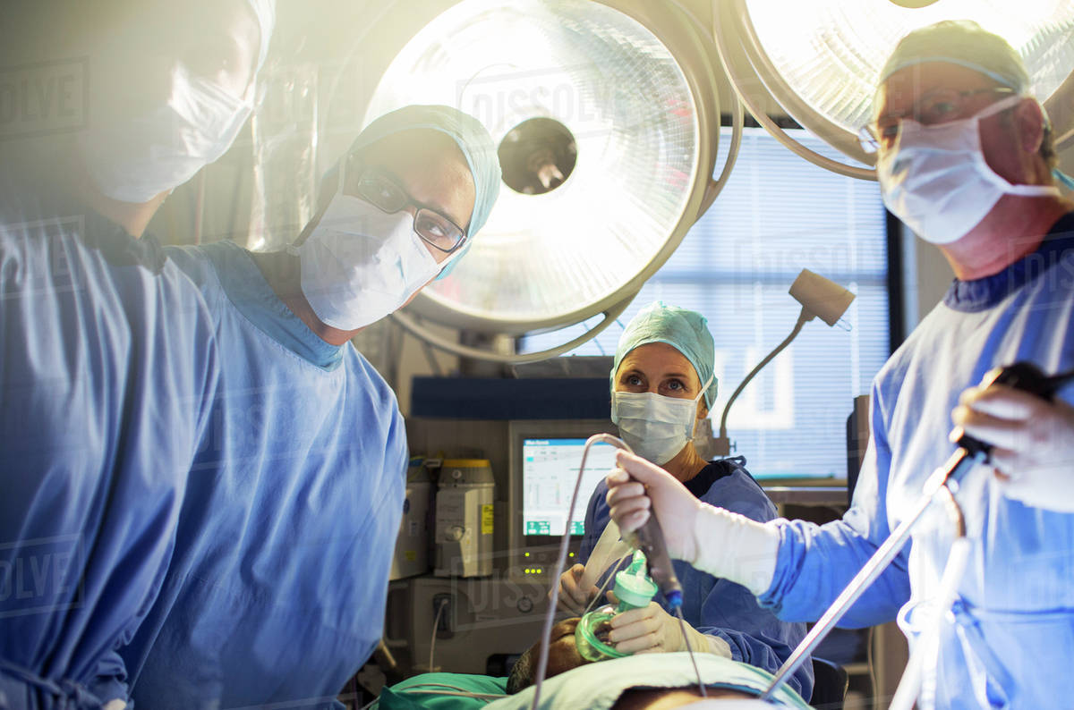 Team of doctors performing laparoscopic surgery in operating theater ...