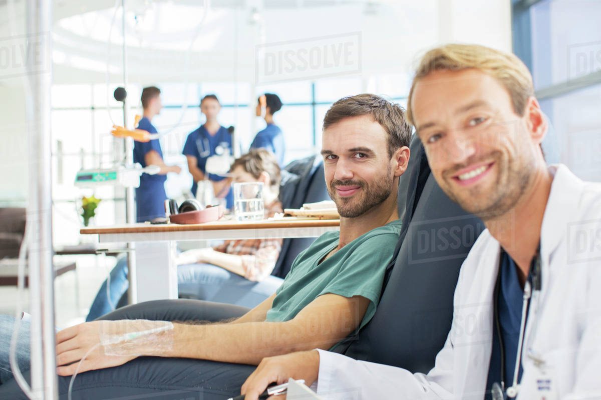 Portrait of smiling doctor and patient undergoing medical treatment in ...