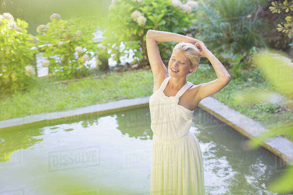Woman standing by pool outdoors - Stock Photo - Dissolve