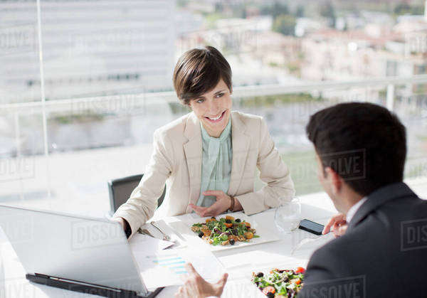 Businessman and businesswoman with laptop meeting over lunch - Royalty ...