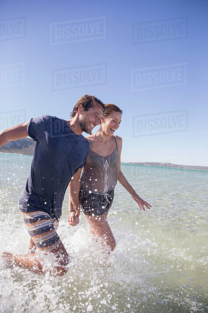 Couple splashing in water together - Royalty-free Stock Photo | Dissolve