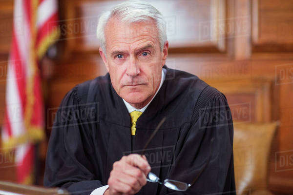 Judge sitting behind judges bench in court - Stock Photo - Dissolve