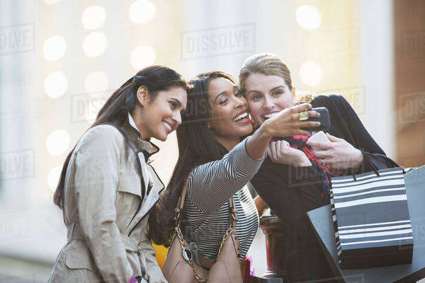 Friends talking picture with cell phone together on city street - Stock ...