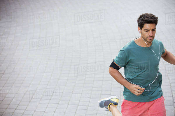 Man running through city streets - Royalty-free Stock Photo | Dissolve