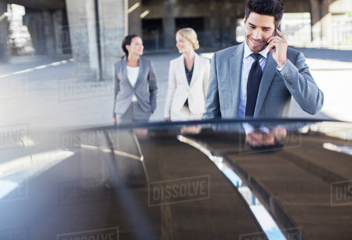 Business people walking towards car in parking garage - Royalty-free ...