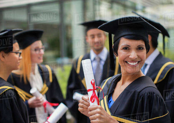 Student in cap and gown smiling with colleges - Royalty-free Stock ...