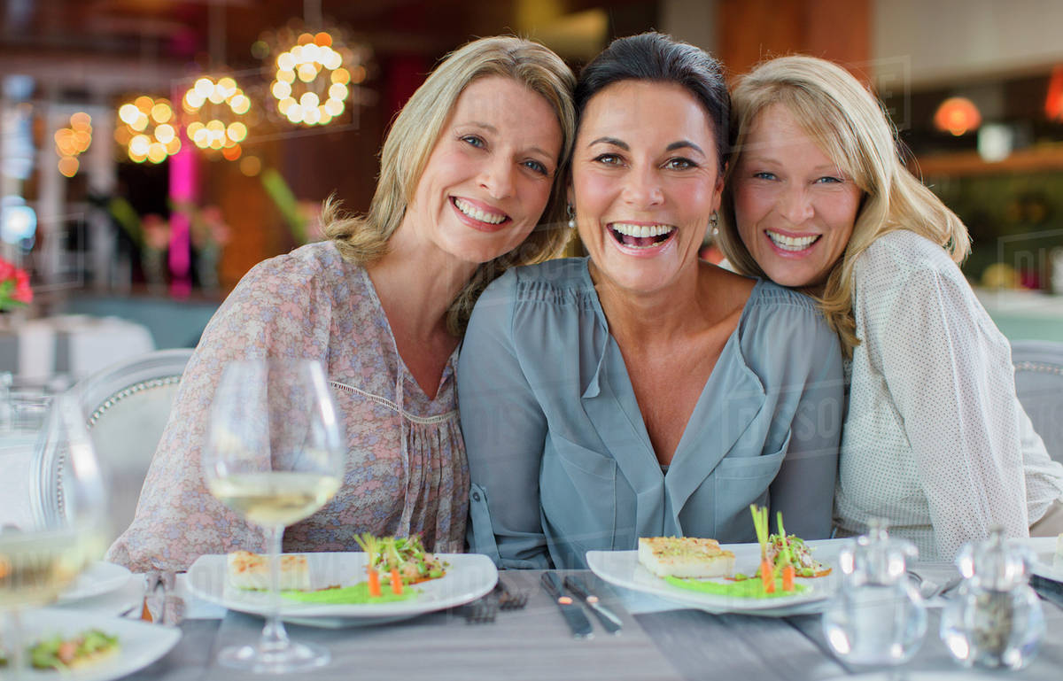 Portrait of smiling women in restaurant - Stock Photo - Dissolve