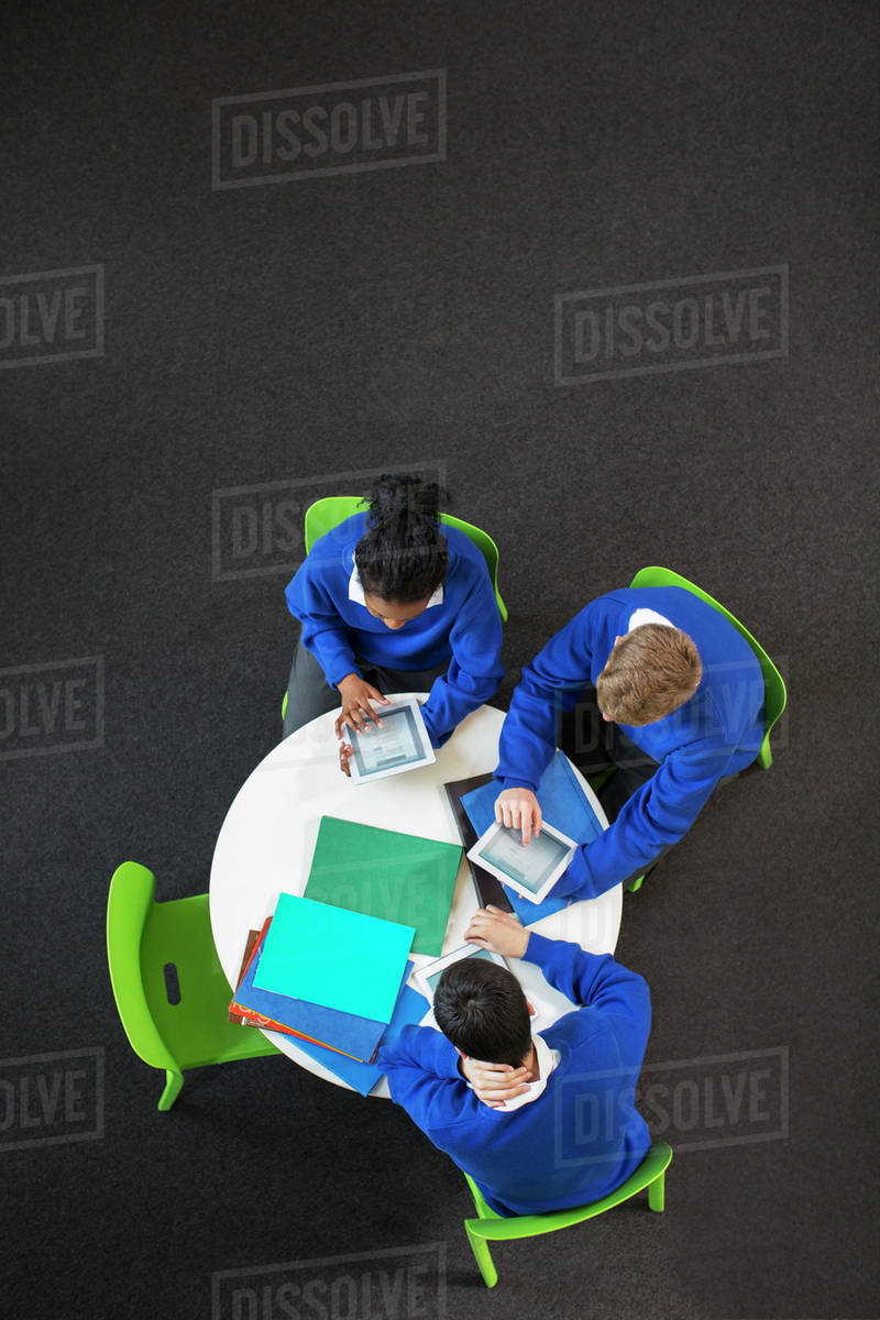 Overhead view of high school students sitting at round table with ...