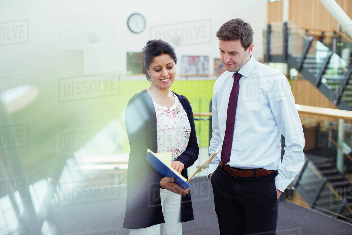 Two smiling teachers talking in corridor in high school - Royalty-free ...
