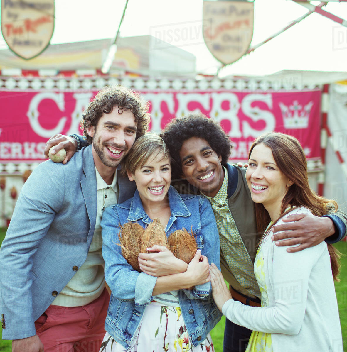 Portrait of four friends having fun in amusement park - Royalty-free ...