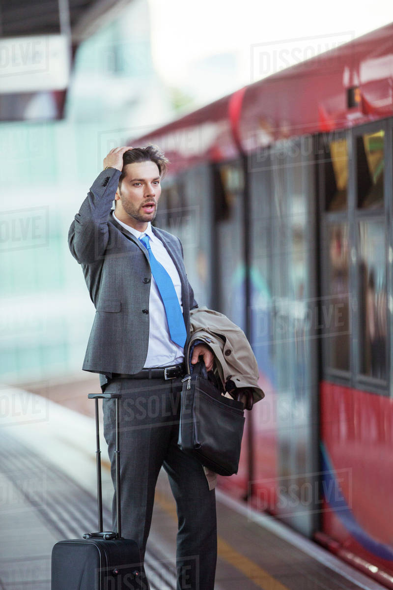 Frustrated businessman missing train in train station - Stock Photo ...