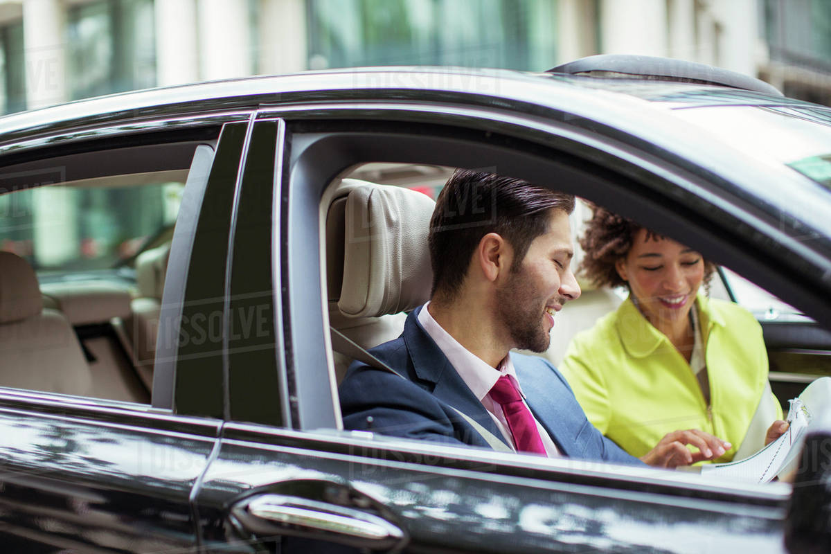 Business people reading paperwork in car - Stock Photo - Dissolve