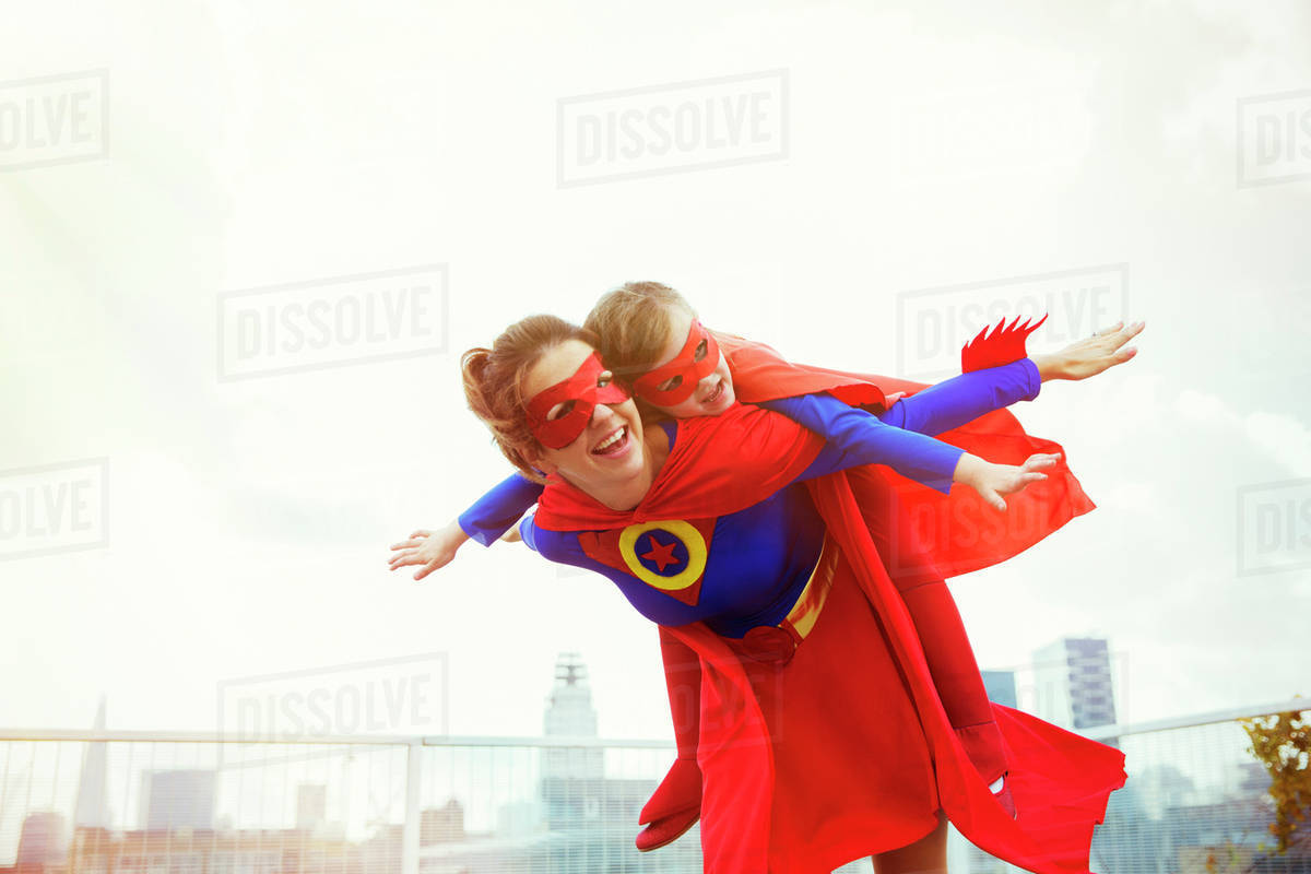 Superhero mother and daughter playing on city rooftop - Royalty-free ...
