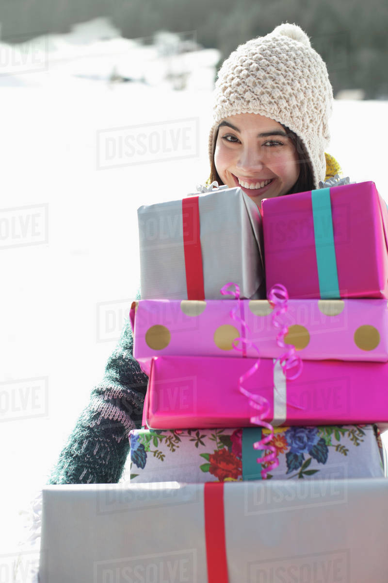Portrait of smiling woman carrying stack of gifts - Royalty-free Stock ...