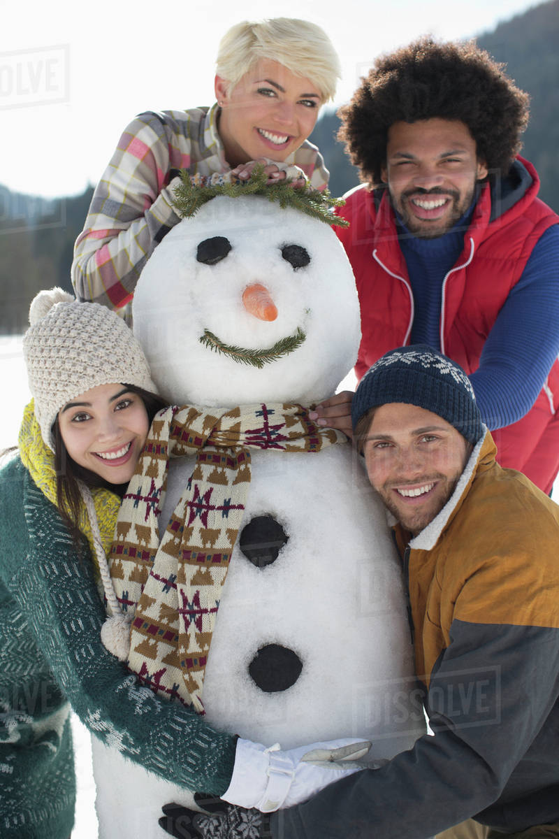 Portrait of friends with snowman - Stock Photo - Dissolve