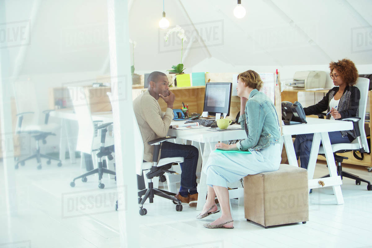 Office workers talking at desk - Royalty-free Stock Photo | Dissolve